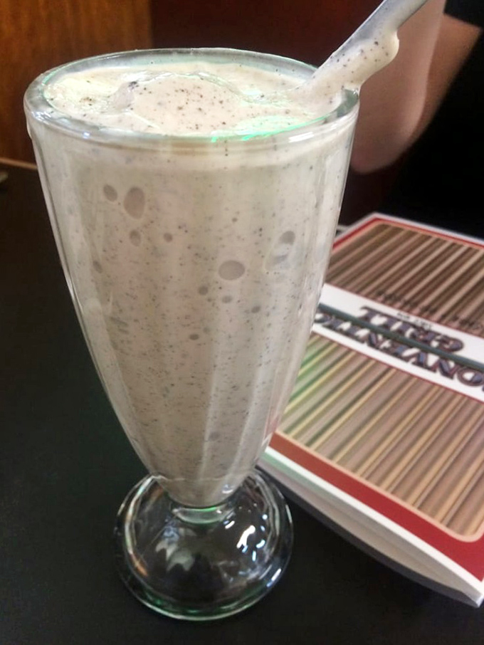 The malt arrives in its ceremonial glass with tiny bubbles promising creamy, cold perfection—like drinking a childhood memory, only better.