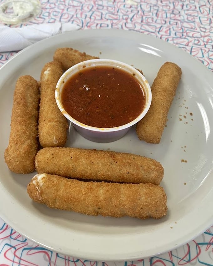Golden mozzarella sticks with marinara dipping sauce—proof that sometimes the simplest pleasures are the ones we keep coming back for.