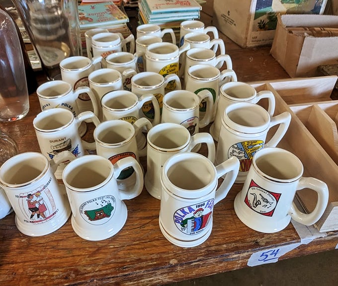 A battalion of mugs stands at attention, each one a souvenir from someone's journey. Your morning coffee never tasted better than from a mug with history.