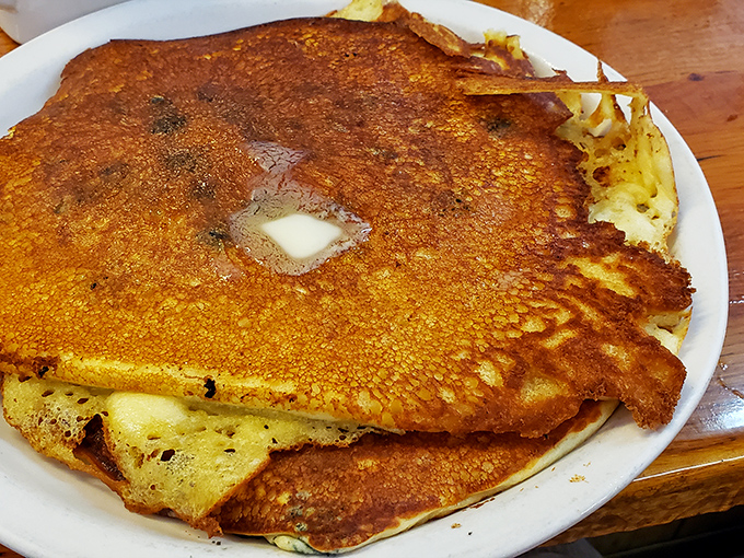 Behold the pancake that ate Boulder! This golden disc of joy extends beyond its plate, a testament to diner generosity.