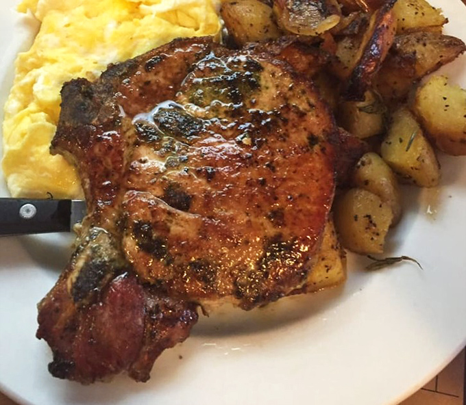 The Chop & Chick in all its glory—a beautifully seared pork chop alongside fluffy scrambled eggs and herb-roasted potatoes that redefine breakfast indulgence.