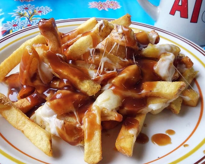 Poutine perfection in the Pine Tree State. Golden fries swimming in gravy with cheese curds melting into gooey pockets of joy &ndash; a Canadian dream in Maine.