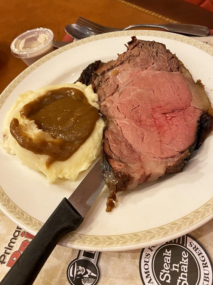 Prime rib so tender it practically surrenders to your knife, paired with mashed potatoes waiting for their gravy baptism.