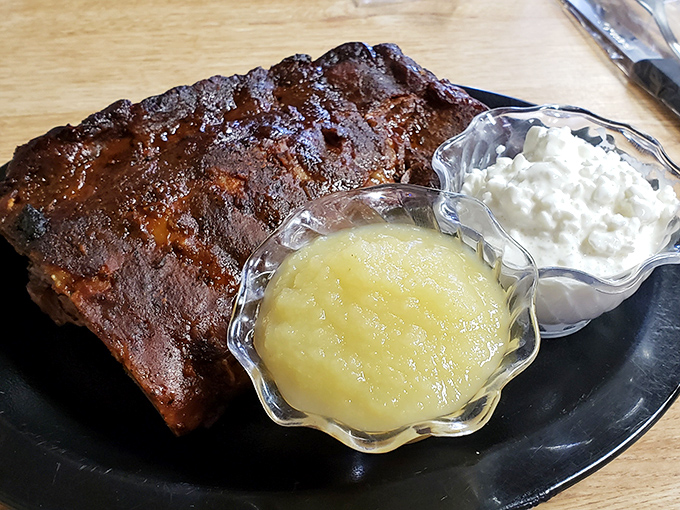 Ribs with sides of applesauce and cottage cheese&mdash;a study in contrasts where smoky meat meets cool, creamy companions in perfect harmony.