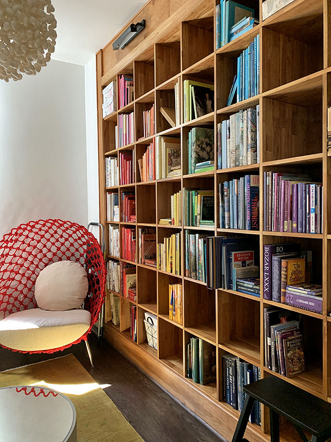 A cozy reading nook with a quirky red chair &ndash; because even book hunters need a moment to rest their finds.