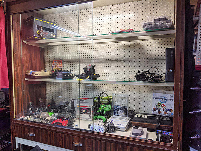 Gaming history displayed behind glass&mdash;from Atari to Nintendo Wii. Each console represents countless hours of childhood joy and parental frustration.