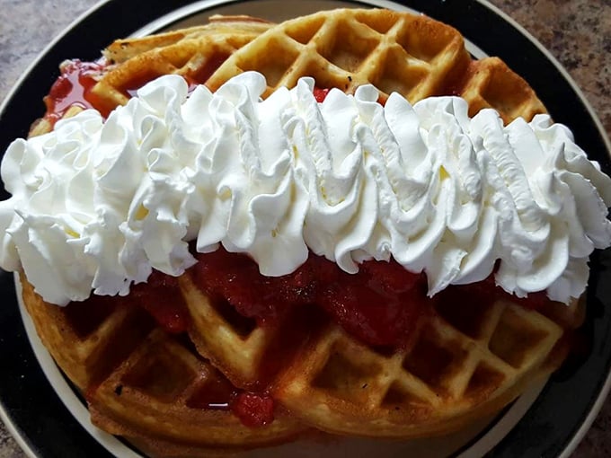 Strawberry waffles topped with a cloud of whipped cream—because sometimes breakfast should look like it's celebrating something.