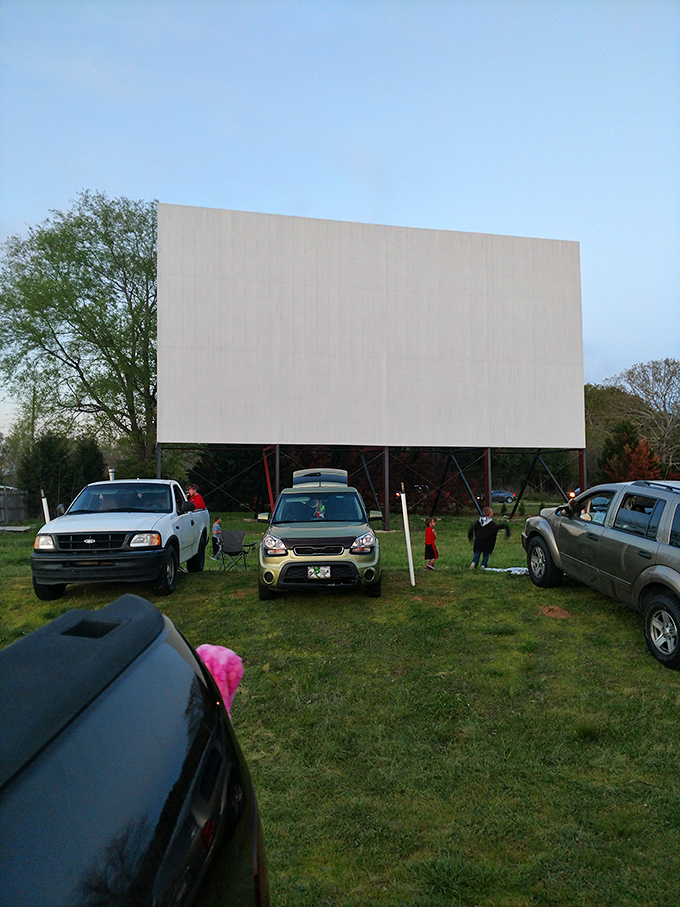 The drive-in's massive screen stands sentinel against the daylight, patiently waiting for darkness to transform into storytelling magic.