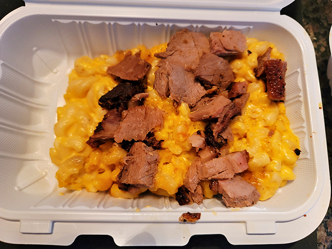 Mac and cheese topped with brisket: where comfort food meets luxury in a styrofoam container that can barely contain the magnificence.