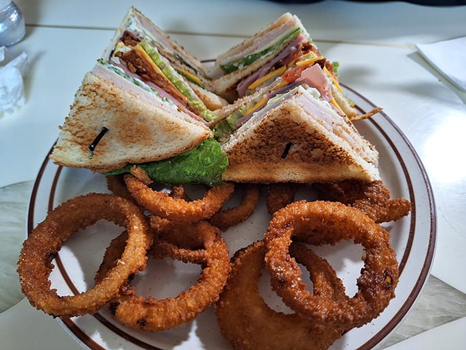 Club sandwich architecture that defies gravity and onion rings with the perfect crunch-to-tenderness ratio. A lunch that demands both hands and extra napkins.