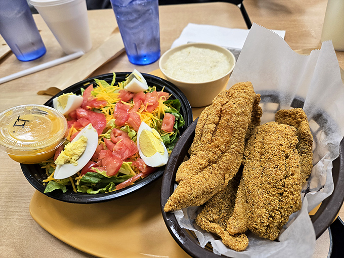 Crispy cornmeal-crusted catfish alongside a fresh salad&mdash;proof that balance in life is possible, even if your diet counselor might disagree.