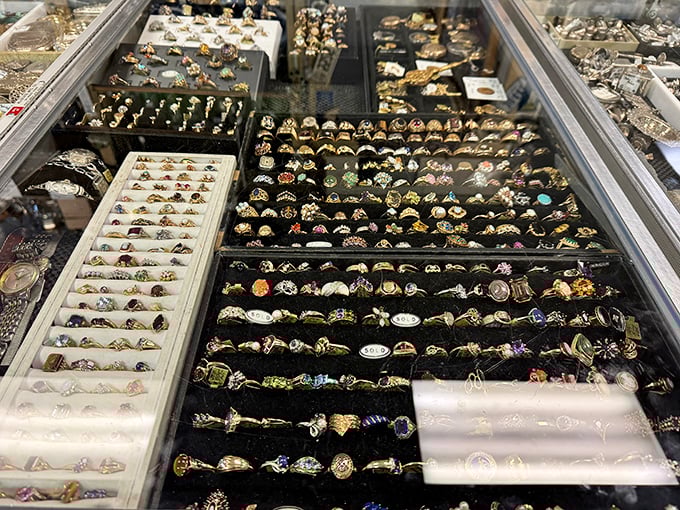 A galaxy of vintage rings sparkles under glass, each one possibly someone's engagement announcement, anniversary gift, or long-forgotten impulse purchase.