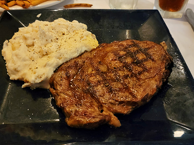 The ribeye doesn't just sit on the plate&mdash;it commands it. With mashed potatoes standing by like a loyal sidekick ready for the flavor journey.