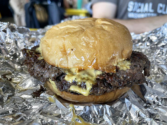 Behold the perfect smash burger – where the patty's crispy edges extend beyond the bun like a meaty sunburst of flavor.