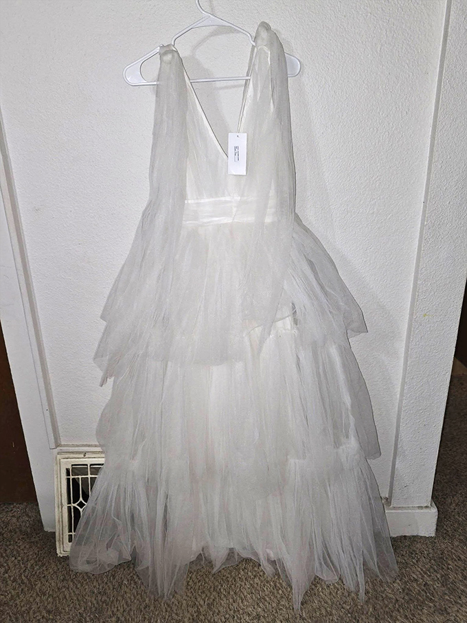 This ethereal white dress isn't just clothing—it's a time machine to someone's special day or perhaps a ghostly Halloween costume.