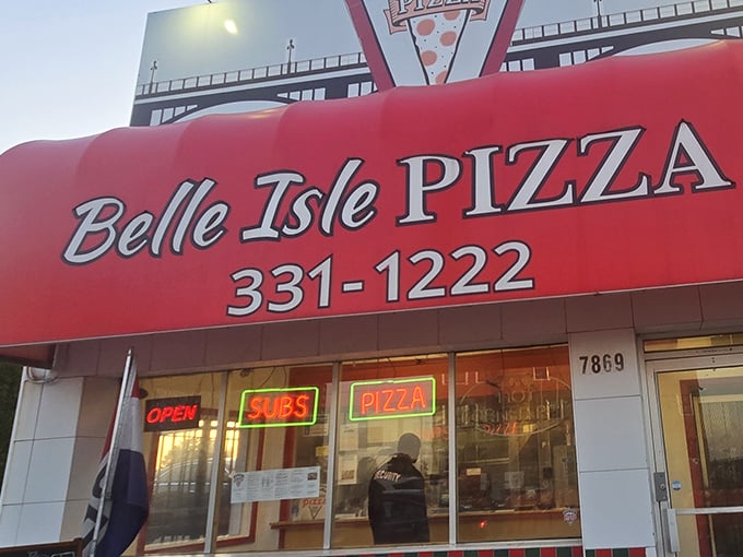 Belle Isle Pizza's bright red awning stands out like a pizza oasis in the urban landscape.