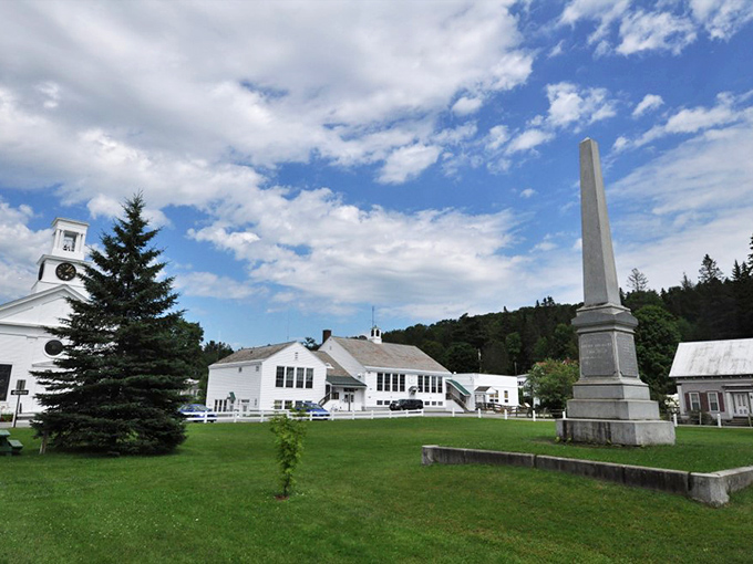 Cabot's town center showcases Vermont's postcard-perfect charm with its white church steeple and historic monument standing proudly against blue skies.
