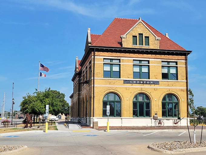 Creston's historic yellow brick depot stands proudly under blue skies, a beautifully preserved piece of Iowa's railroad heritage.