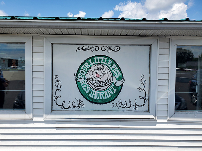 Four Little Pigs' hand-painted sign features the happiest cartoon pig you'll ever see. Ironic, yet somehow heartwarming!