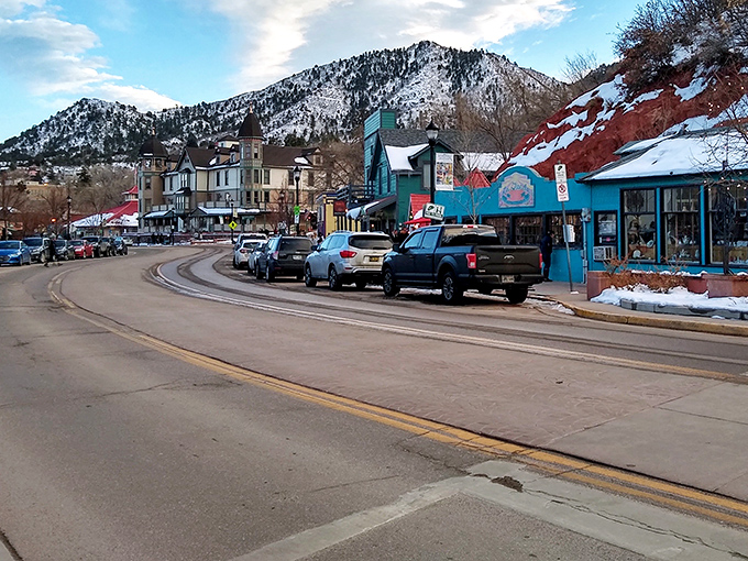 Colorful storefronts line up like a cheerful parade beneath snow-capped peaks that steal the show.