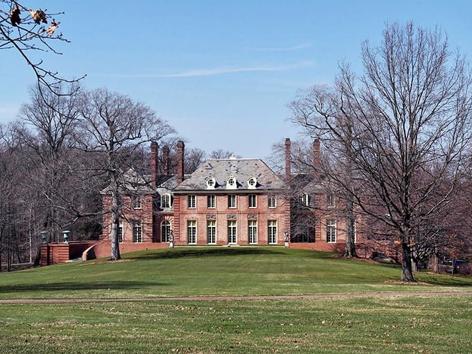Historic mansion in Mansfield showcases elegant architecture amid sprawling green lawns and bare winter trees.