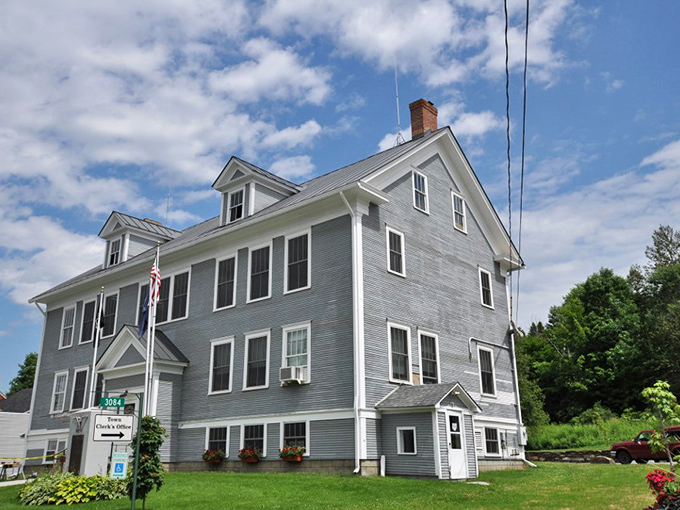 This classic New England municipal building in Cabot could tell a century of stories, its weathered blue-gray clapboards housing the heart of small-town governance.