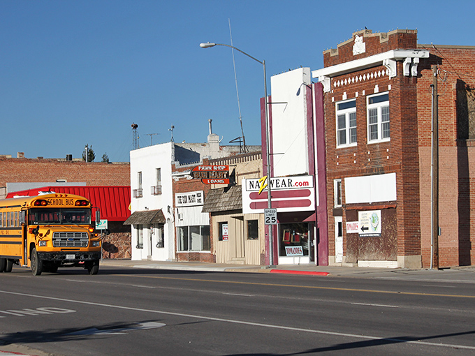 A yellow school bus rolls past Gering's historic downtown, proving small-town life still runs on its own sweet schedule.