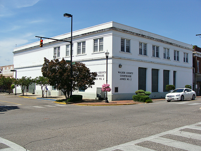 The crisp white Walker County Courthouse annex stands proudly under blue Alabama skies, surrounded by manicured shrubs and small-town tranquility.