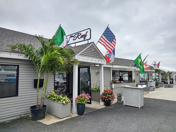 Colorful flags flutter above The Reef's entrance, promising a global seafood journey without ever leaving Newport's historic harbor.