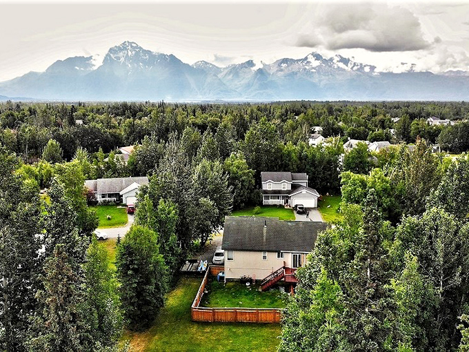 Suburban serenity in Wasilla, where backyard fences frame picture-perfect views of Alaska's majestic mountain ranges.