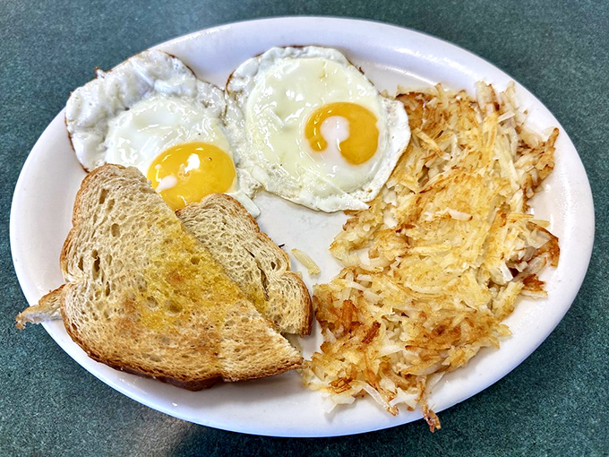 The classic breakfast trinity: perfectly cooked eggs, golden hash browns, and toast – simplicity that never goes out of style.