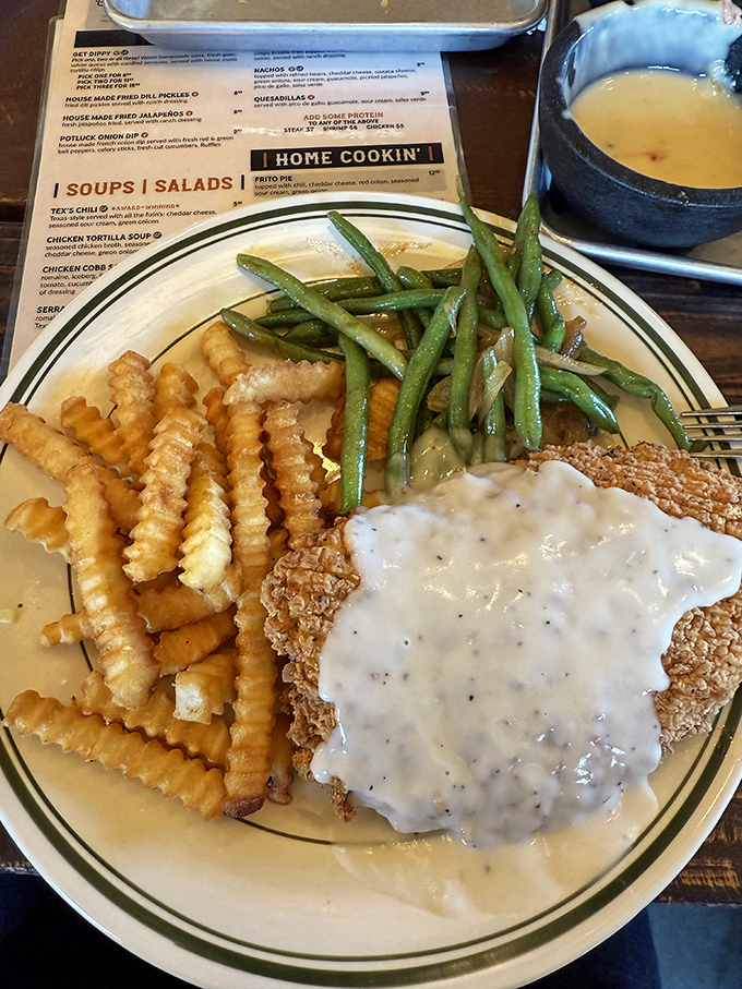 Chicken fried to golden perfection, smothered in pepper gravy, with green beans that didn't come from a can. Texas on a plate.