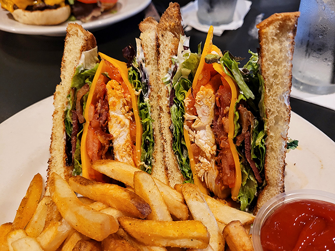 Architecture you can eat! Tucker's club sandwich stands tall and proud, layered with care and flanked by golden fries that demand equal attention.