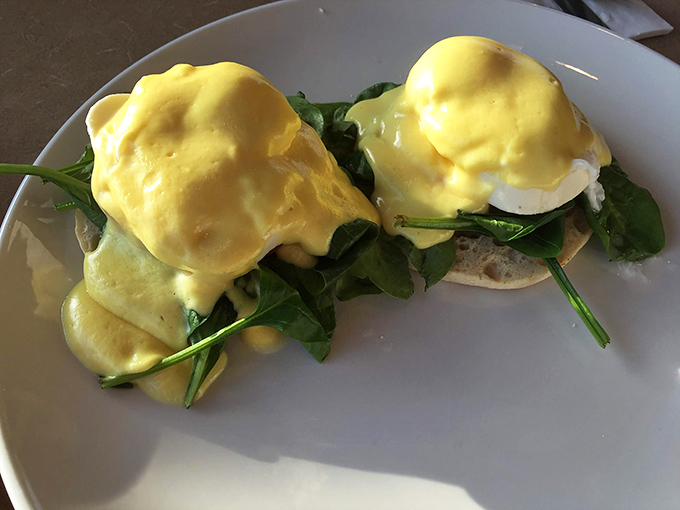 Eggs Benedict: where hollandaise sauce flows like liquid gold over perfectly poached eggs. Spinach sneaks in to make you feel virtuous about your decadent choices.