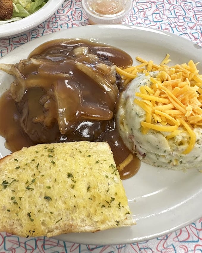 Hamburger steak swimming in rich brown gravy with a side of loaded mashed potatoes—comfort food that whispers, "Everything's gonna be alright."