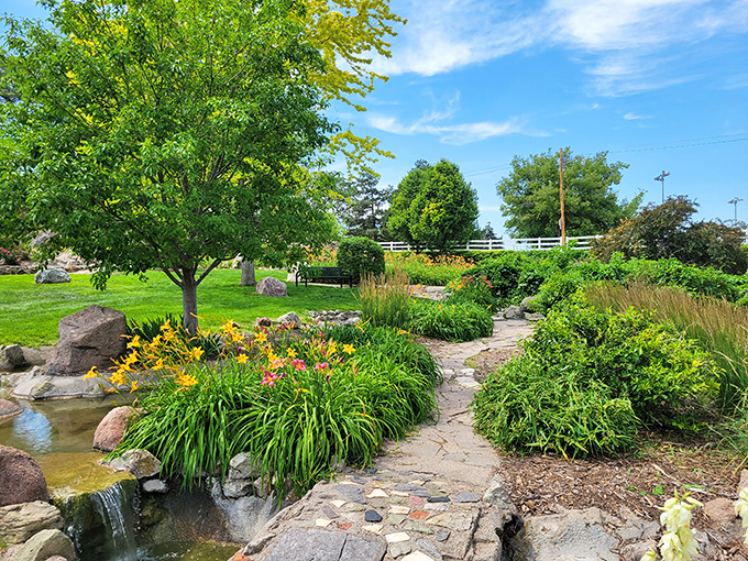 A stone pathway meanders through Harmon Park's lush gardens, where water features and vibrant flowers create nature's perfect stress antidote.
