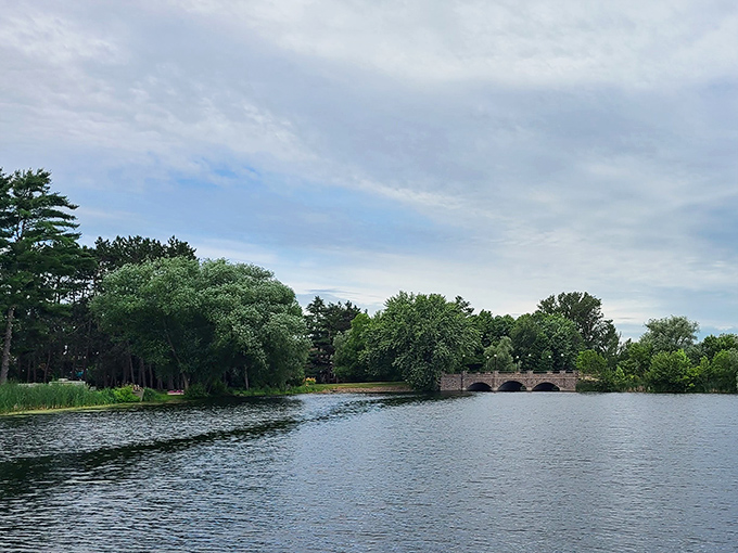 Antigo's lake reflects clouds like nature's own Instagram filter, the stone bridge adding just the right touch of storybook charm.