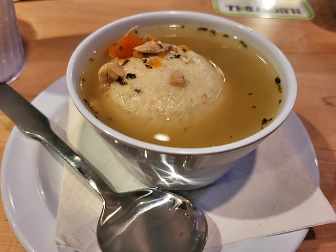 One perfect matzo ball floats in golden broth, ready to cure whatever ails you with every spoonful.