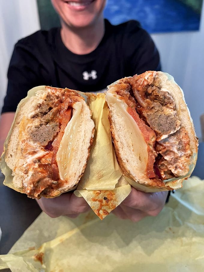 Someone's holding what might be the world's most perfect meatball sandwich. The cheese pull alone deserves its own Instagram account.
