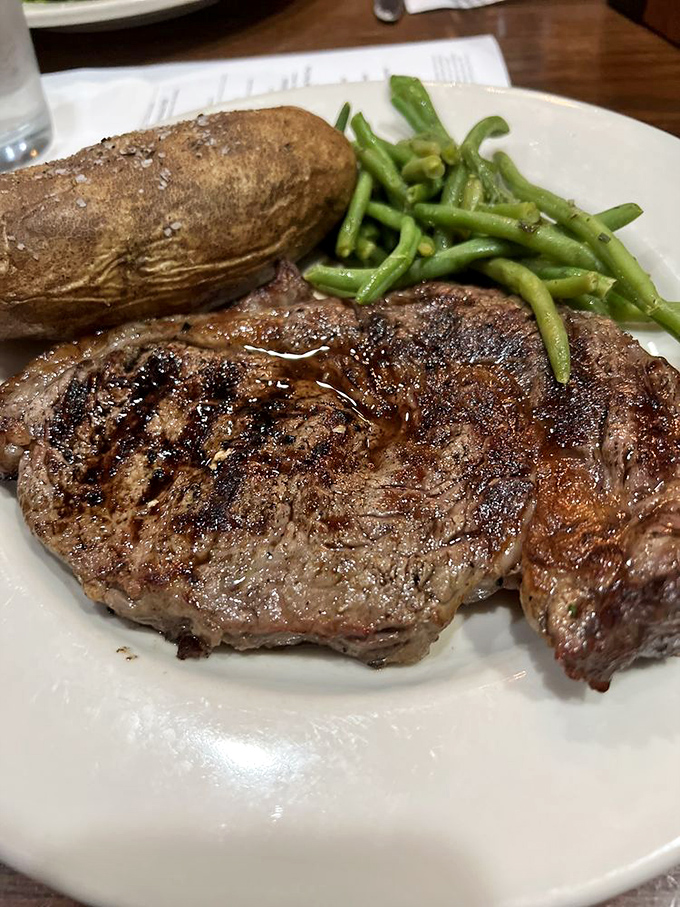 A ribeye with a sear so perfect it deserves its own Instagram account, accompanied by green beans that didn't come from a can.