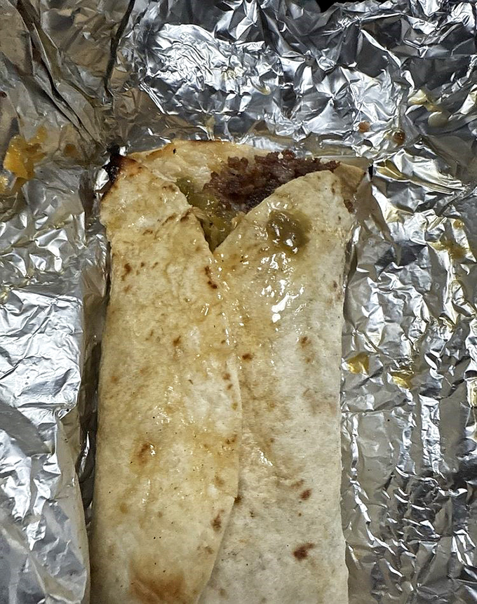 Morning salvation, aluminum-wrapped. The green chile's gentle glow through the tortilla promises a breakfast experience worth setting your alarm for.