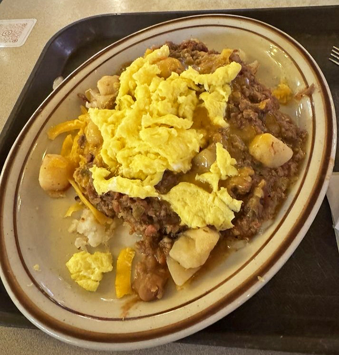 A mountain of comfort on a plate&mdash;scrambled eggs crowning what appears to be a glorious mess of potatoes, meat, and chile. Hangover cure? Absolutely.