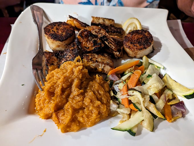 Seafood platter featuring perfectly seared scallops alongside colorful vegetables&mdash;a coastal Florida sunset arranged on fine china.
