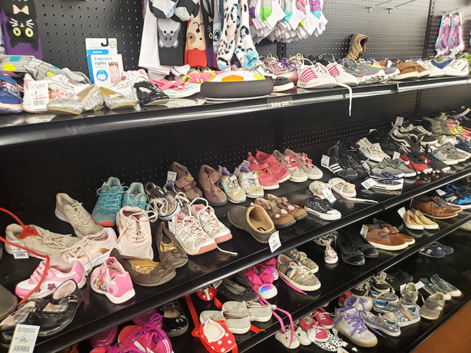 Children's shoes lined up like tiny soldiers, each pair having supported first steps, playground adventures, and growth spurts before finding their way here.