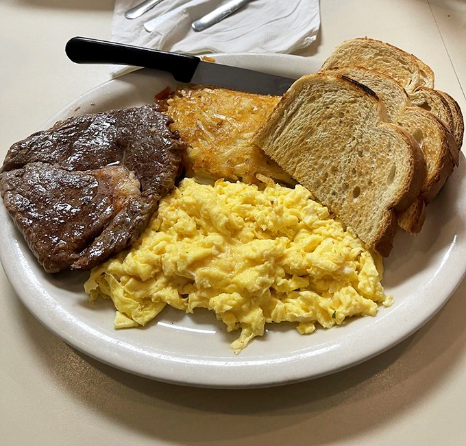 The breakfast power trio: perfectly scrambled eggs, a steak that means business, and hash browns that didn't come from a freezer bag.