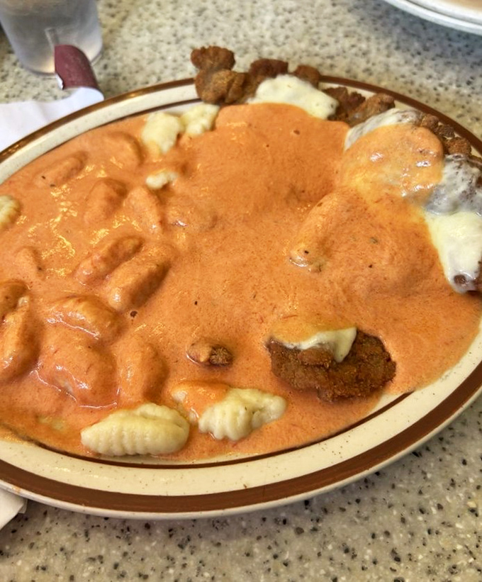 Veal parmesan swimming in vodka sauce with pillowy gnocchi—a plate that whispers, "Diet starts tomorrow, enjoy me today."