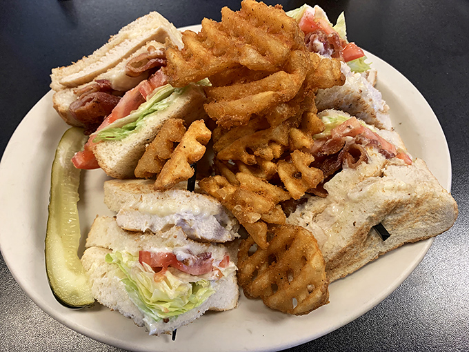 The club sandwich &ndash; a towering monument to lunch perfection with waffle fries standing guard like delicious sentinels.