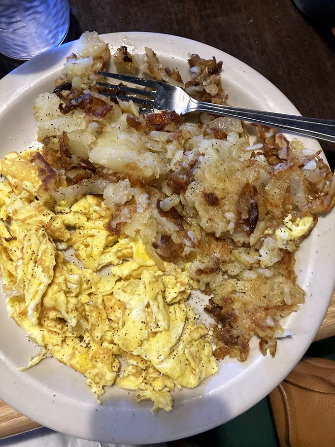 The breakfast purist's dream plate. Perfectly scrambled eggs beside hash browns with that magical crispy-outside, tender-inside contradiction.