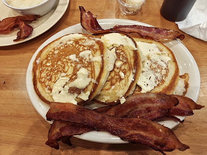 Pancakes so fluffy they could float away, anchored only by strips of bacon that redefine the meaning of "thick-cut." Breakfast perfection exists.