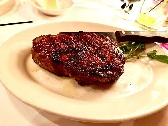 A steak so perfectly seared it should come with its own soundtrack. The knife stands ready for the ceremonial first cut.